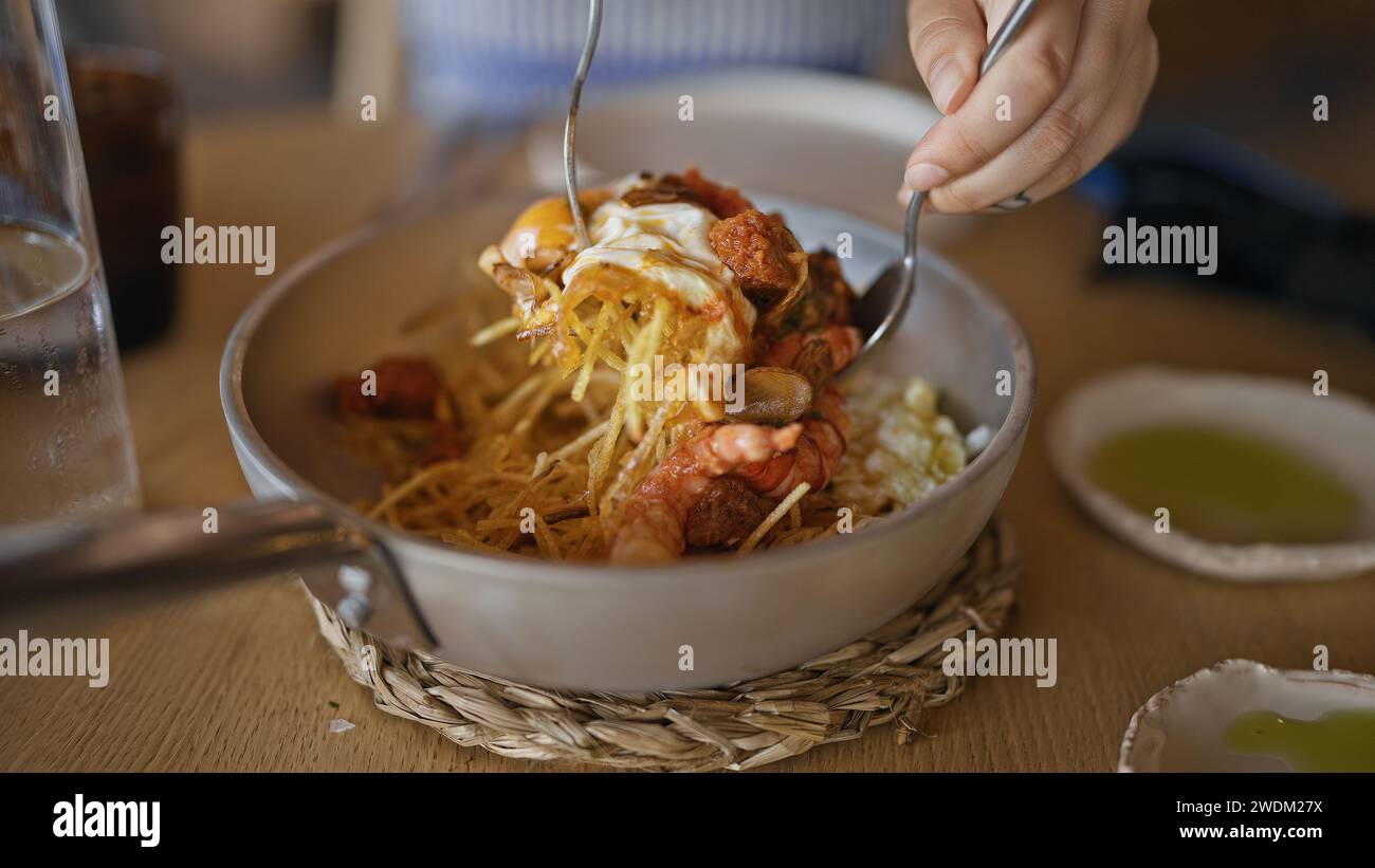 Young hispanic woman mixing food with cutlery at the restaurant Stock ...