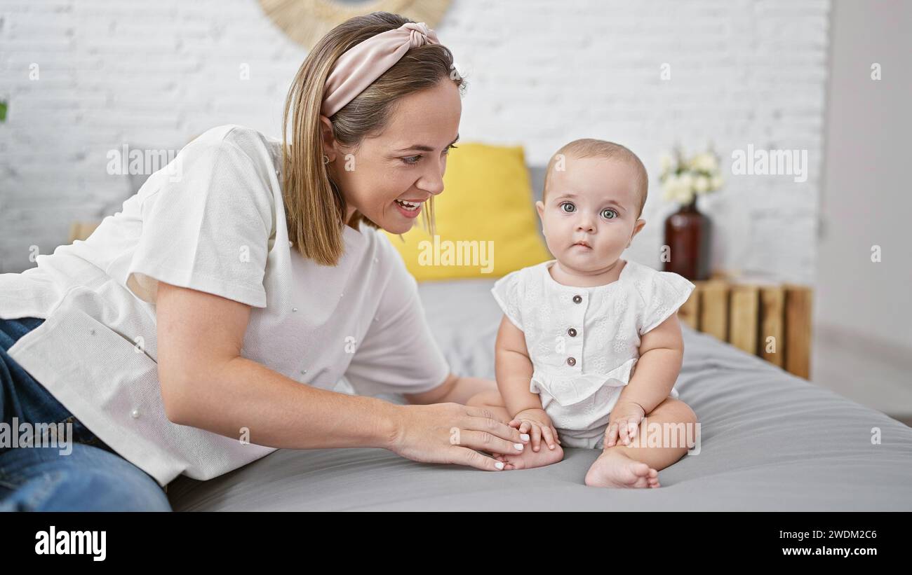 Confident mother and baby daughter sharing a joyful moment, sitting ...