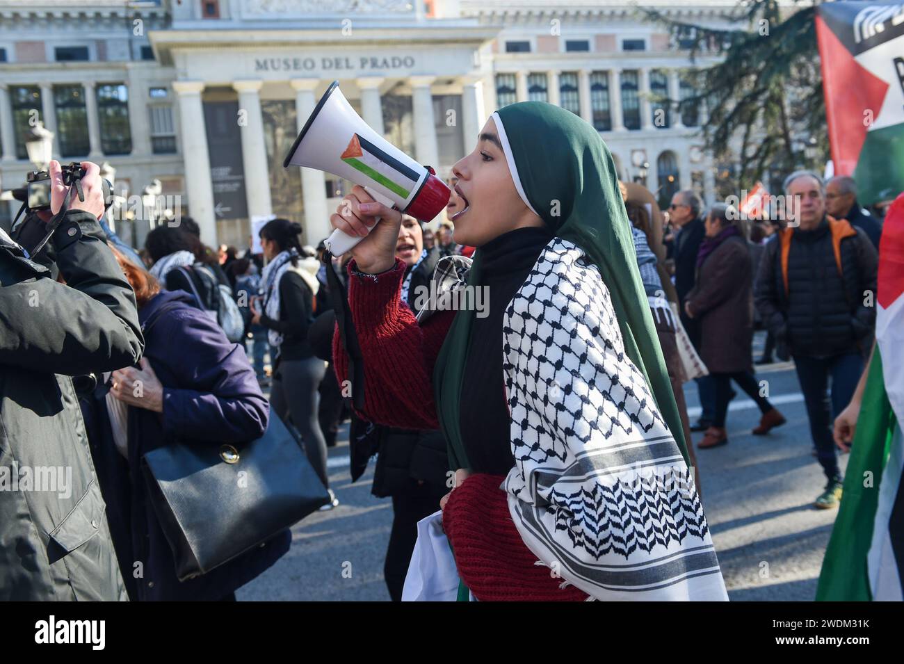 A young protester wearing a hijab shouts slogans on a megaphone during ...