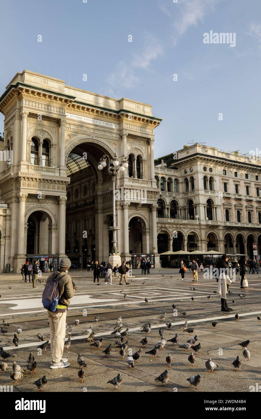 Tourists feeding and photographing the pigeons and the duomo at Piazza ...