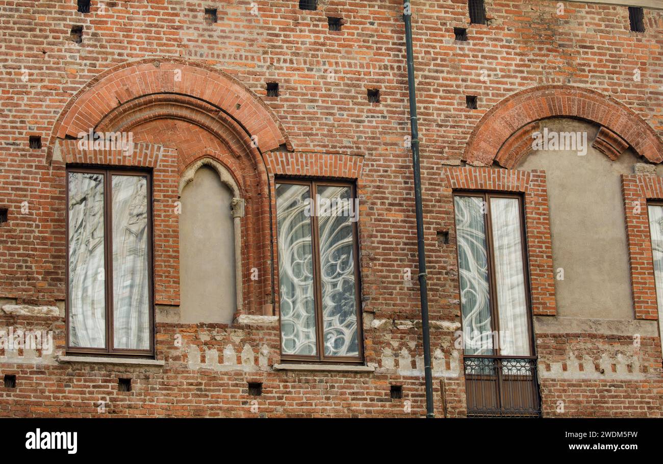 Reflections of Duomo di Milano in thwe old windows of a medieval red ...