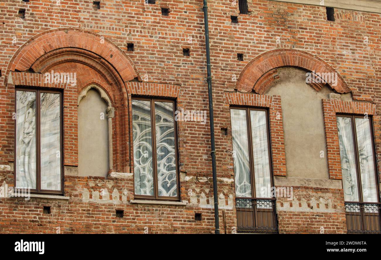 Reflections of Duomo di Milano in thwe old windows of a medieval red ...