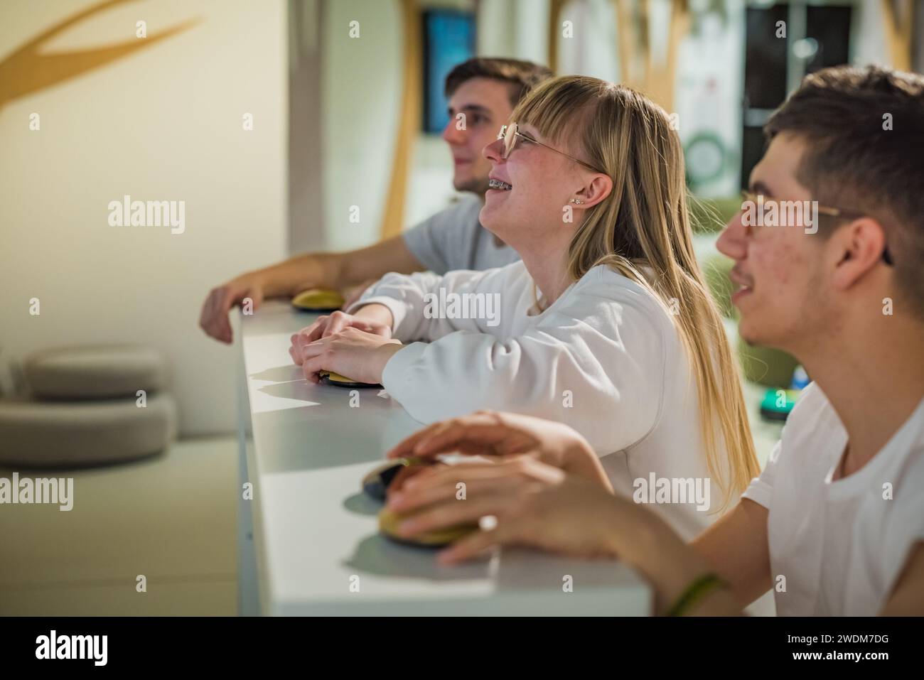 Three teen students, a girl and two boys having fun in an interactive ...