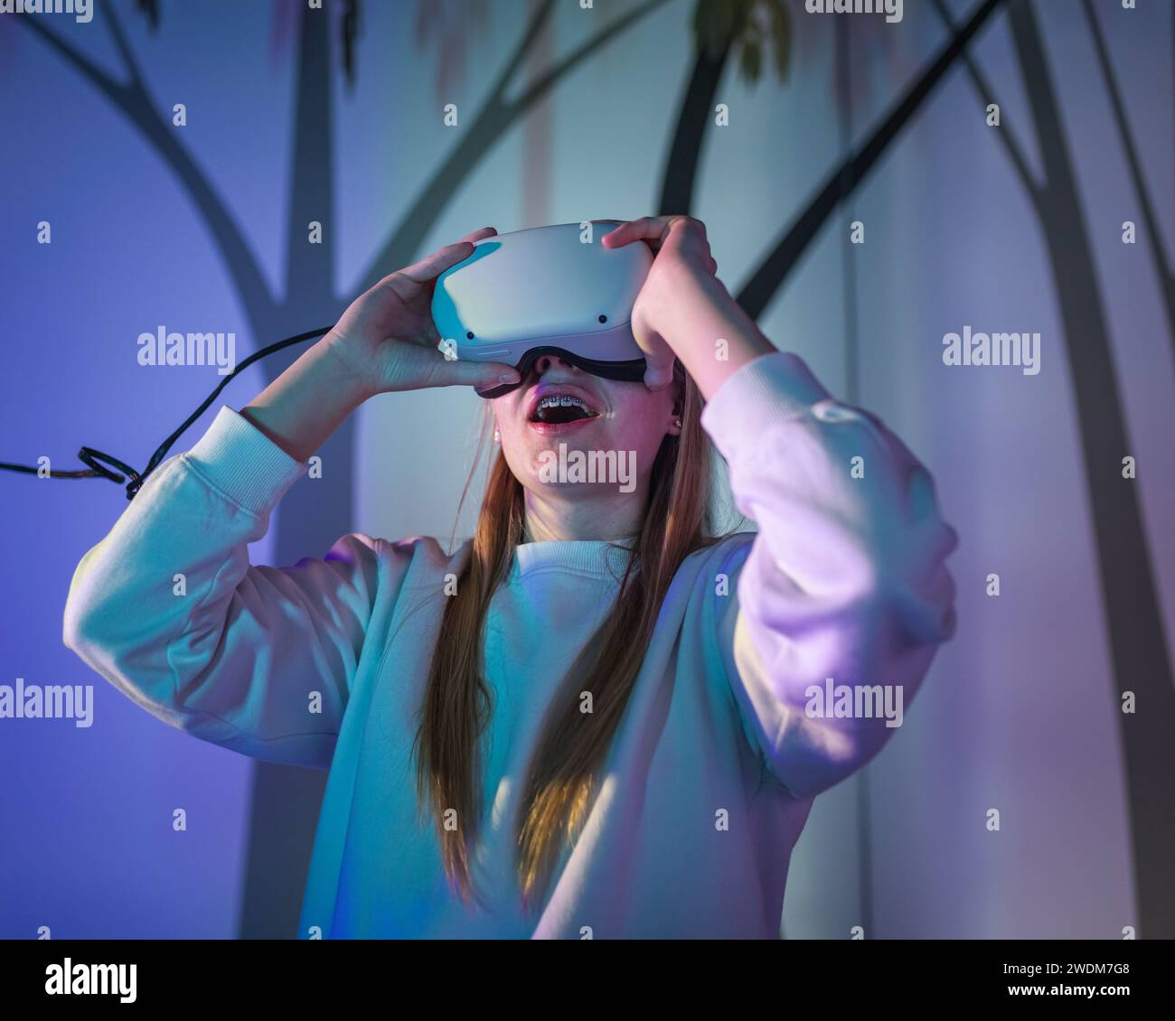 Teenage girl having fun in a natural history museum VR room, wearing ...