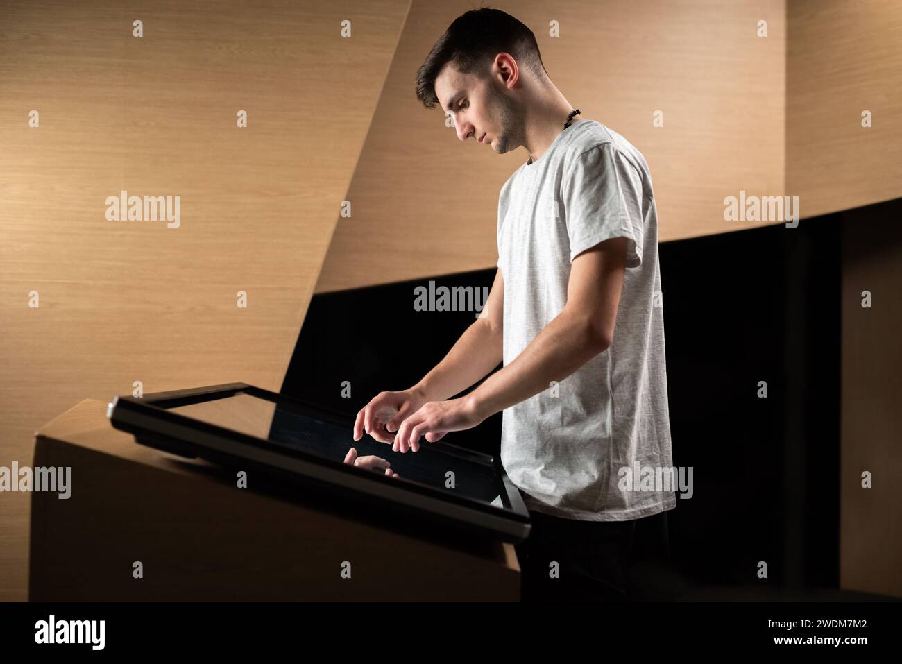 Adolescent boy making hand and finger gestures on the touch screen ...