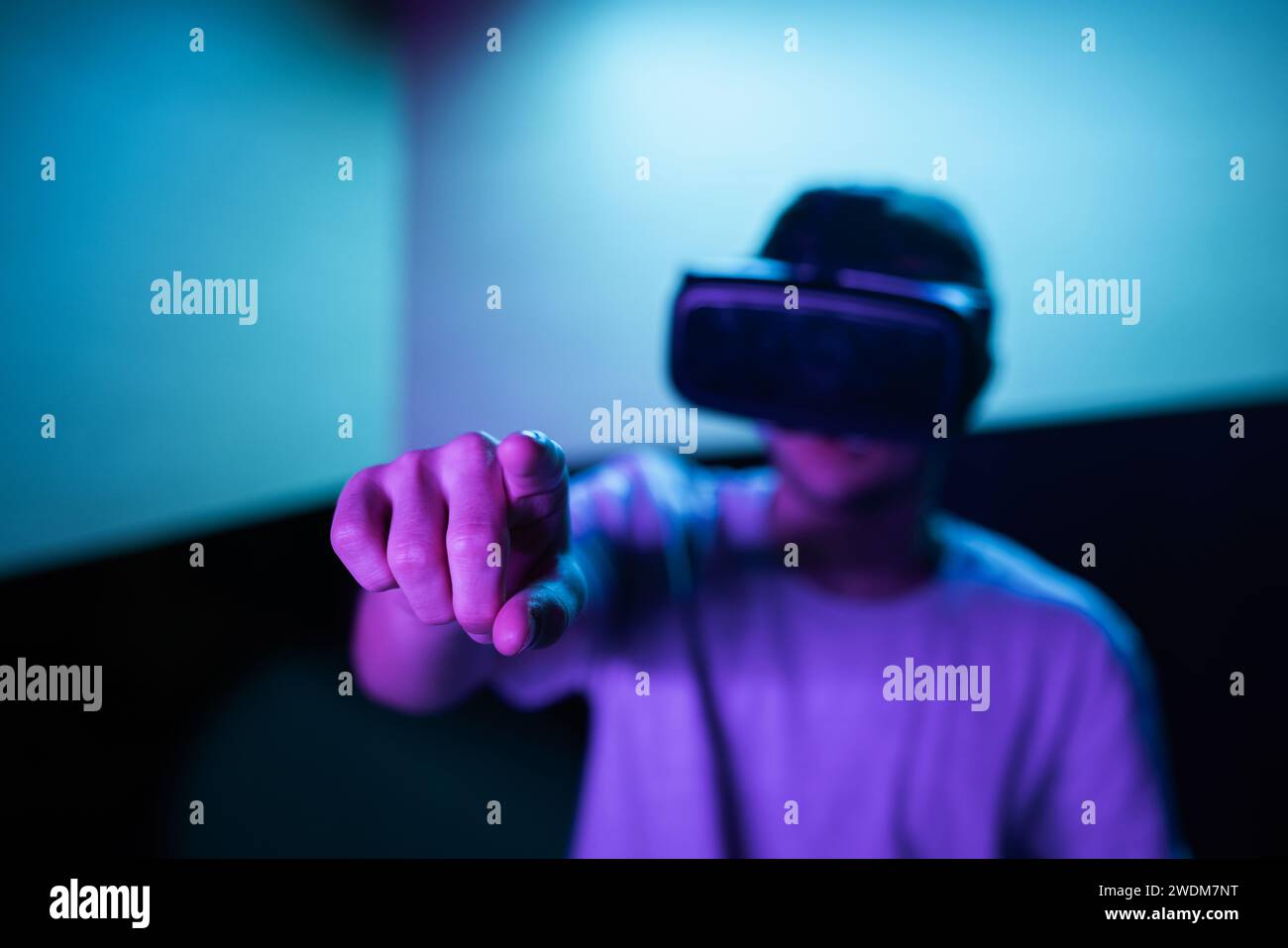 Young man interacting in a digital world, using virtual reality headset ...