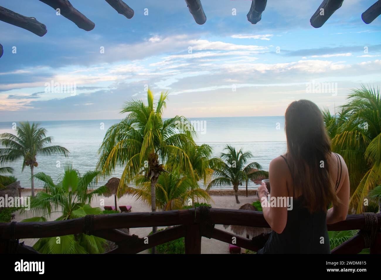 Female enjoying a beautiful balcony sunset in Holbox Mexico Stock Photo ...