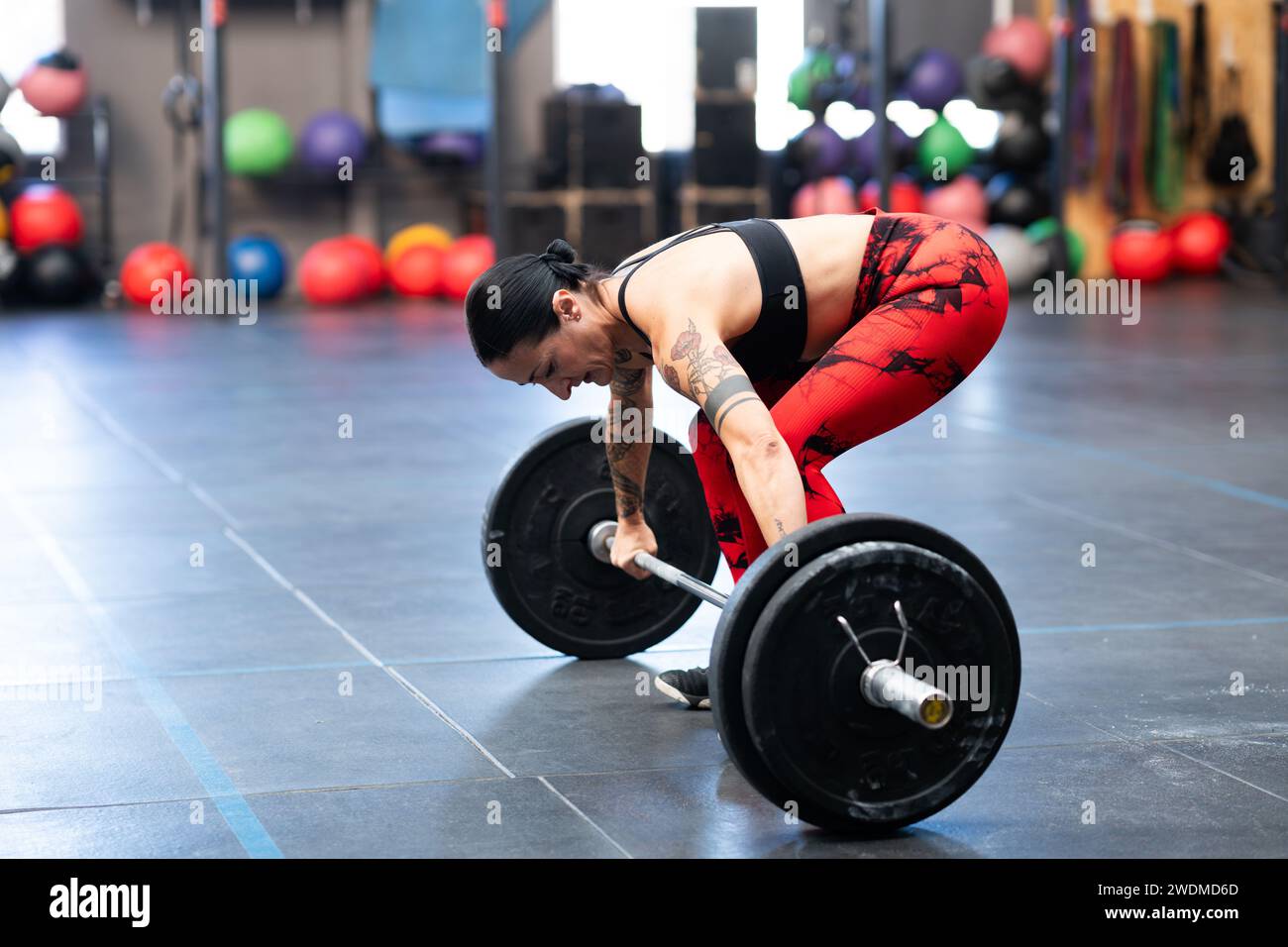 Woman about to lift weight with bar in a gym Stock Photo - Alamy