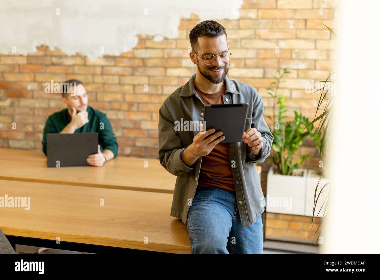 In a contemporary office setting, two focused colleagues engage in ...