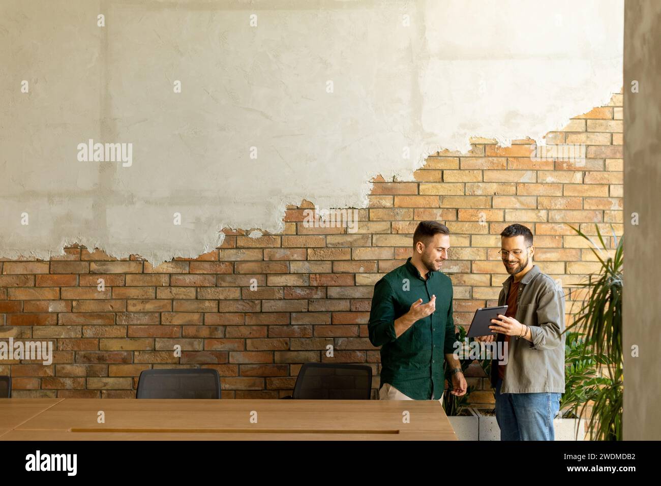 Two professionals are engaged in a focused conversation while holding ...