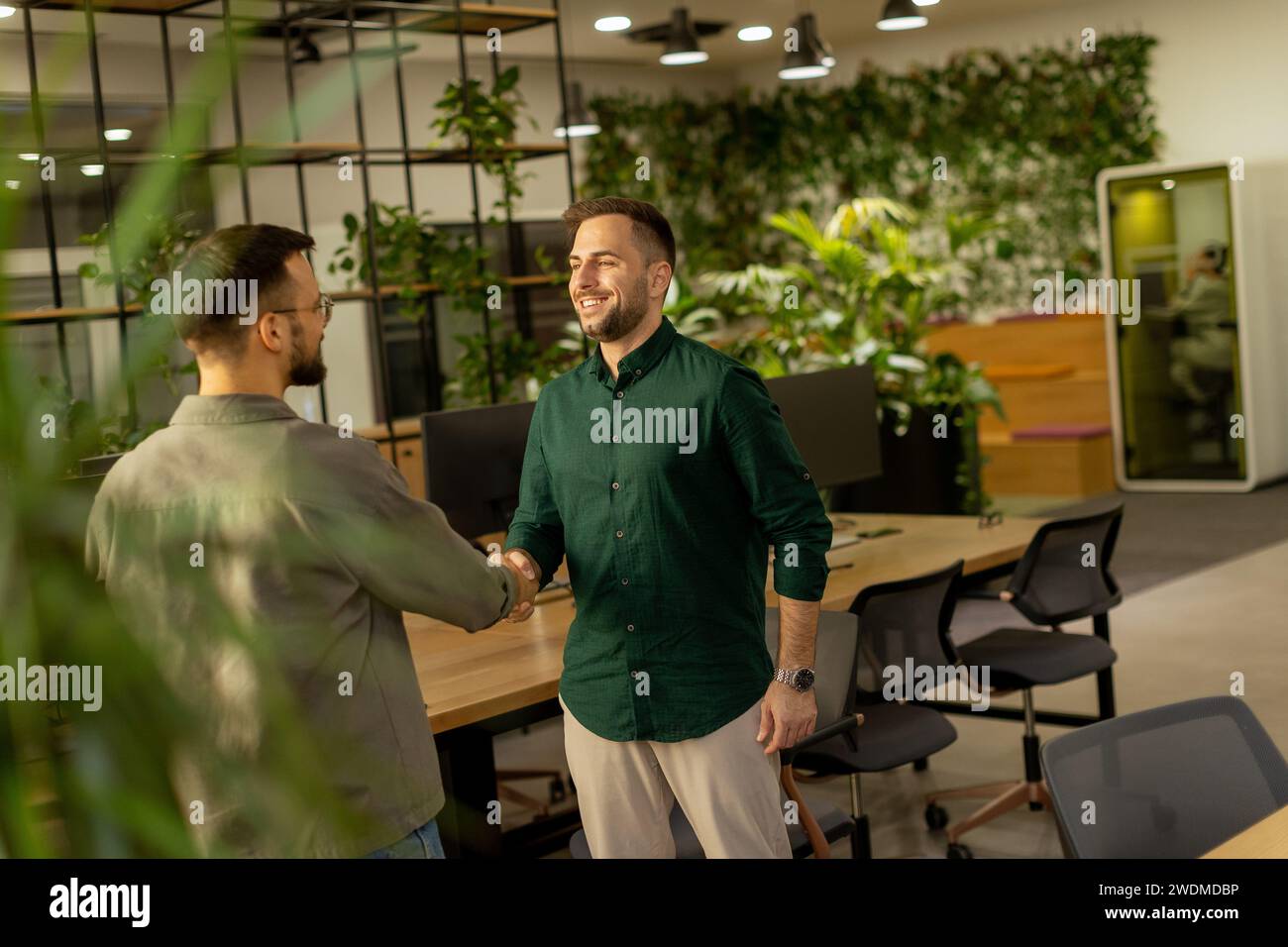 Two professionals exchange a warm handshake in the inviting ambiance of ...