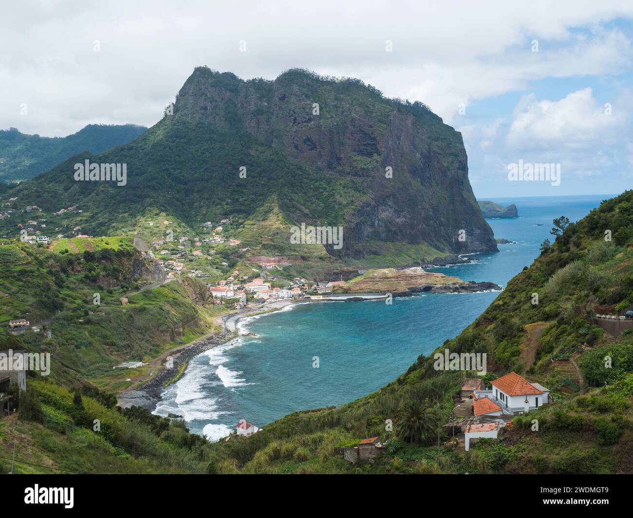 Aerial view of Porto da Cruz town with green cliff of Penha D'Aguia ...