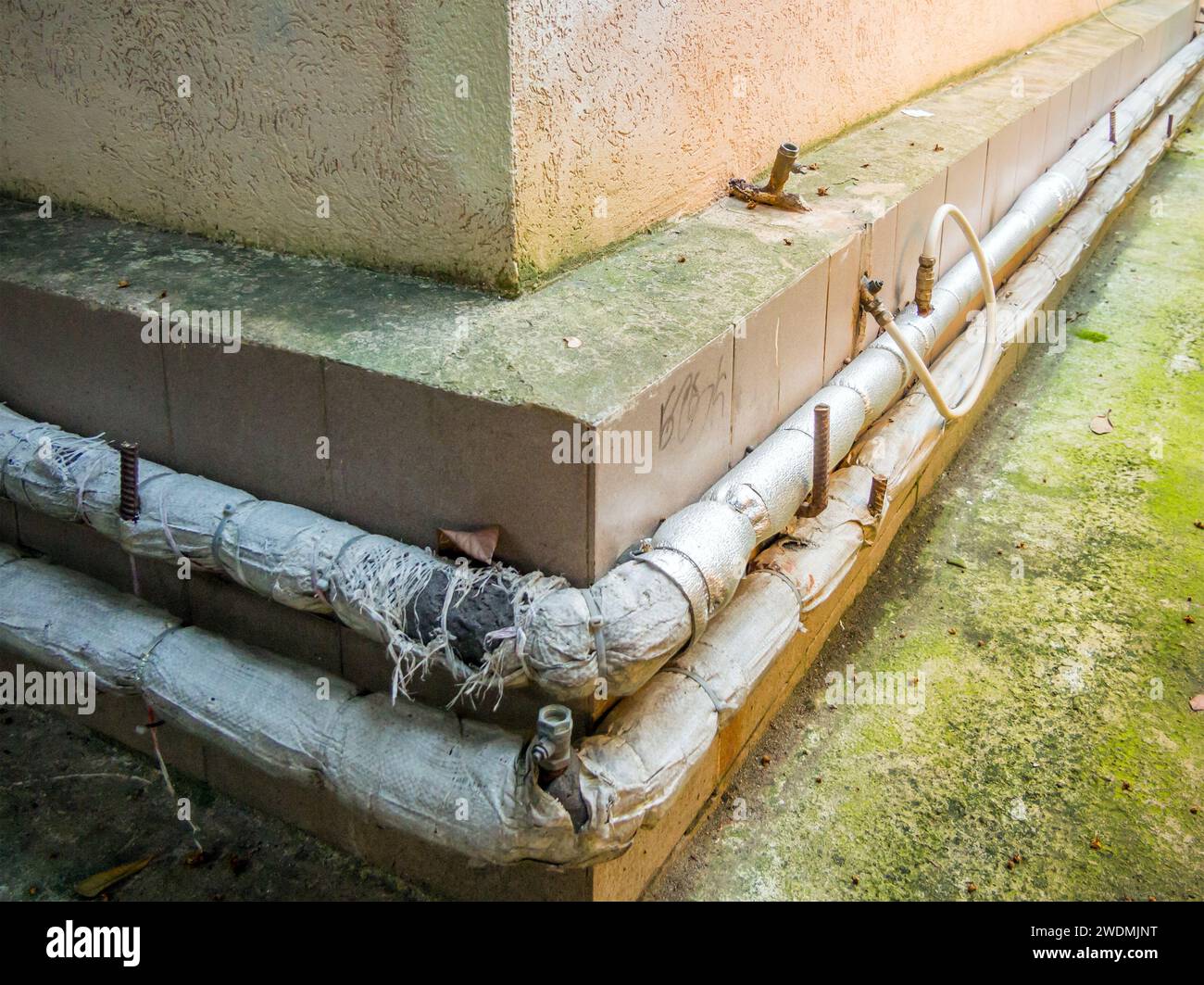 Main heating pipes passing through the foundation outside the building ...