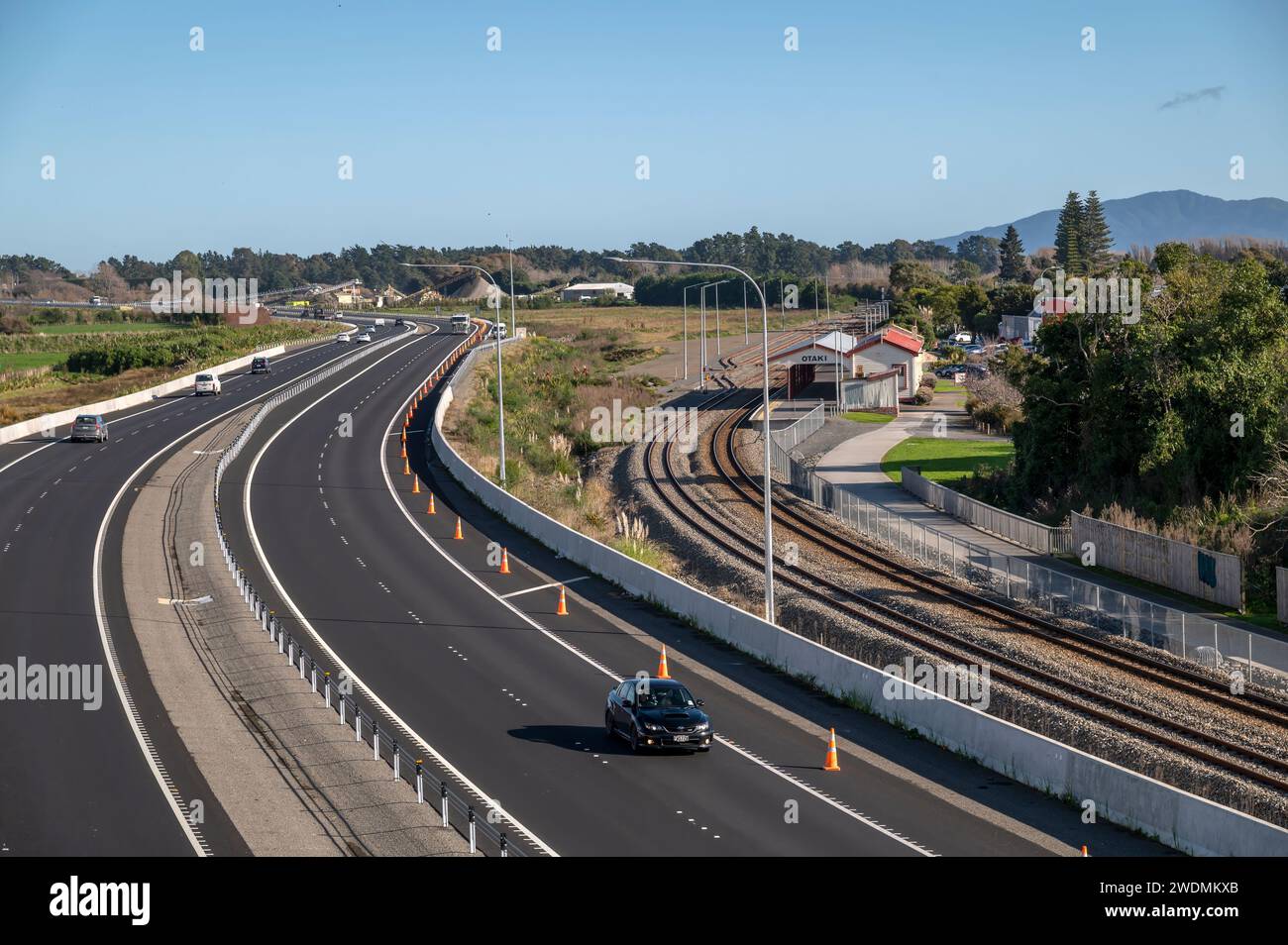 A scenic highway with cars driving alongside a picturesque hill Stock ...