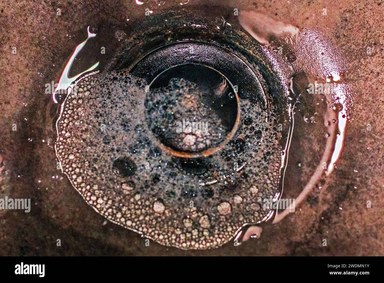 abstract reddish background of liquid pouring through a hole. Plumbing ...
