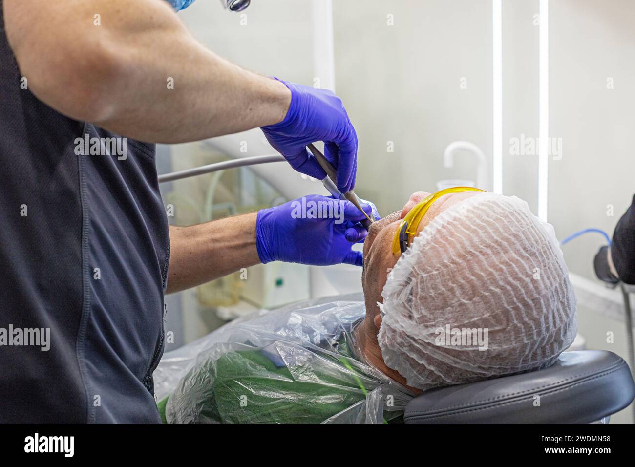 dentist injecting anesthesia into a diseased tooth before treating it ...