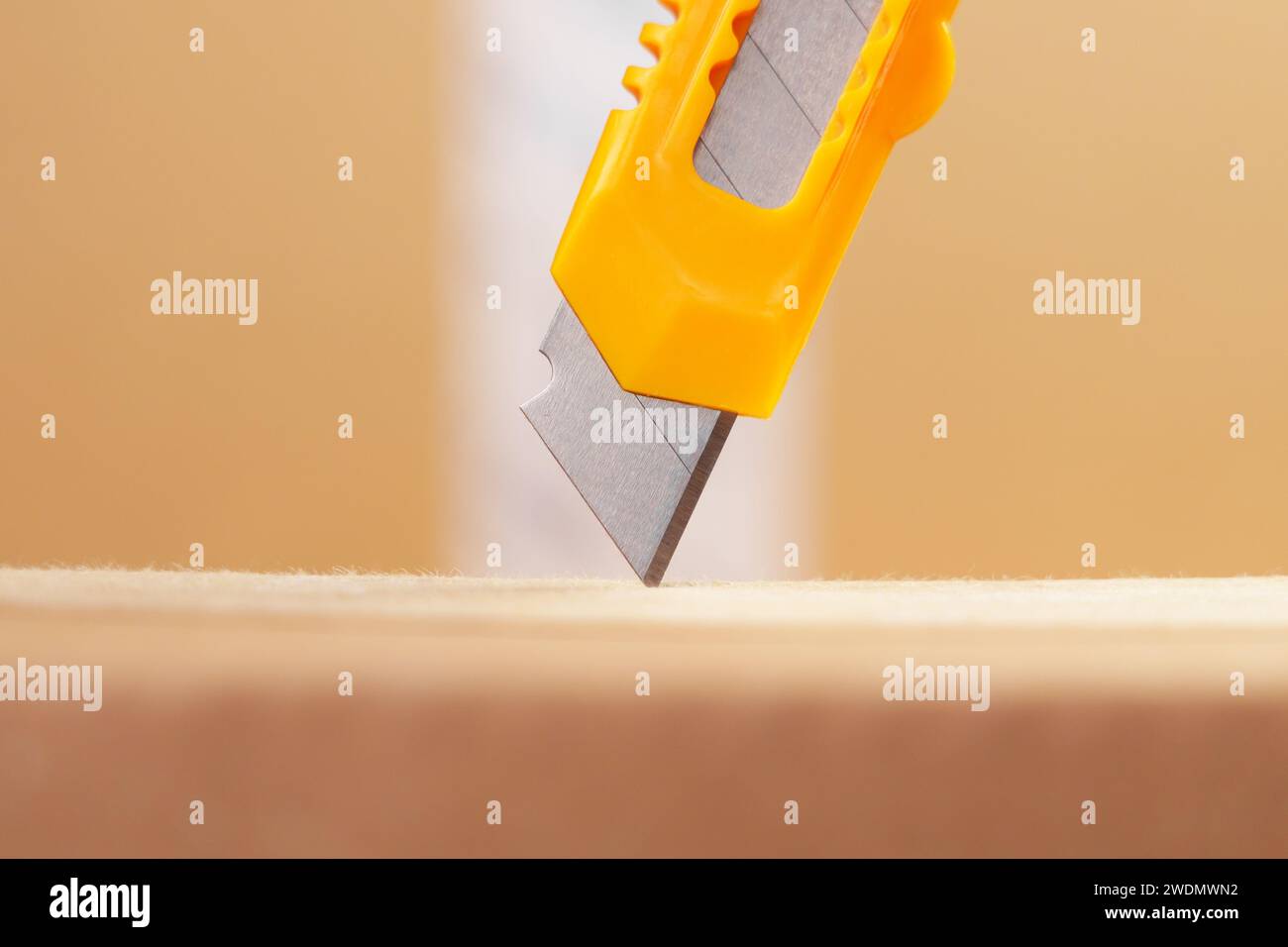 Unpacking an order cutting a parcel cardboard box with a utility knife ...