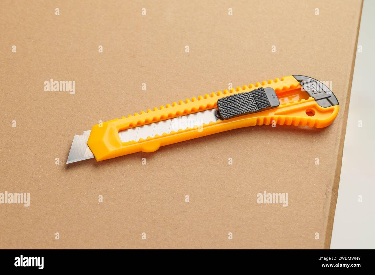Box cutter on a parcel cardboard box close up. Retractable utility ...