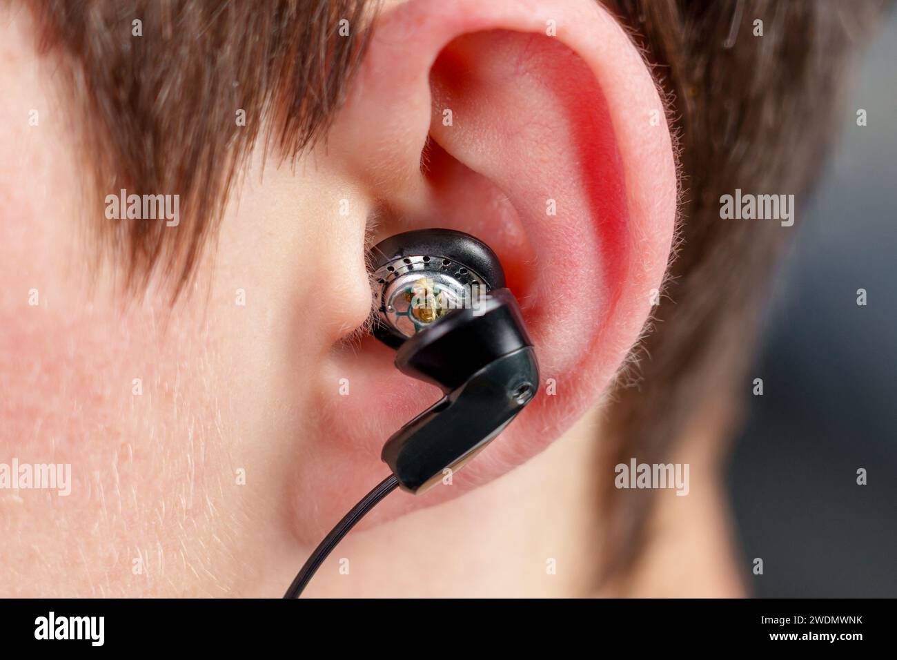 Damaged broken headphone in a young man ear. Breaking the connection ...