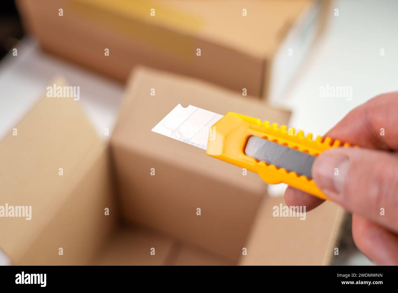 Retractable blade of a utility knife and a pile of received parcel ...