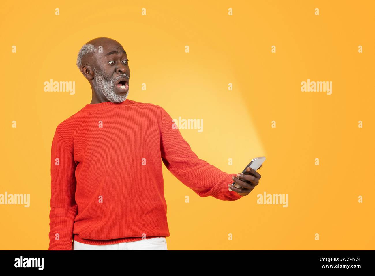 Shocked elderly African American man in a red sweater and white pants ...