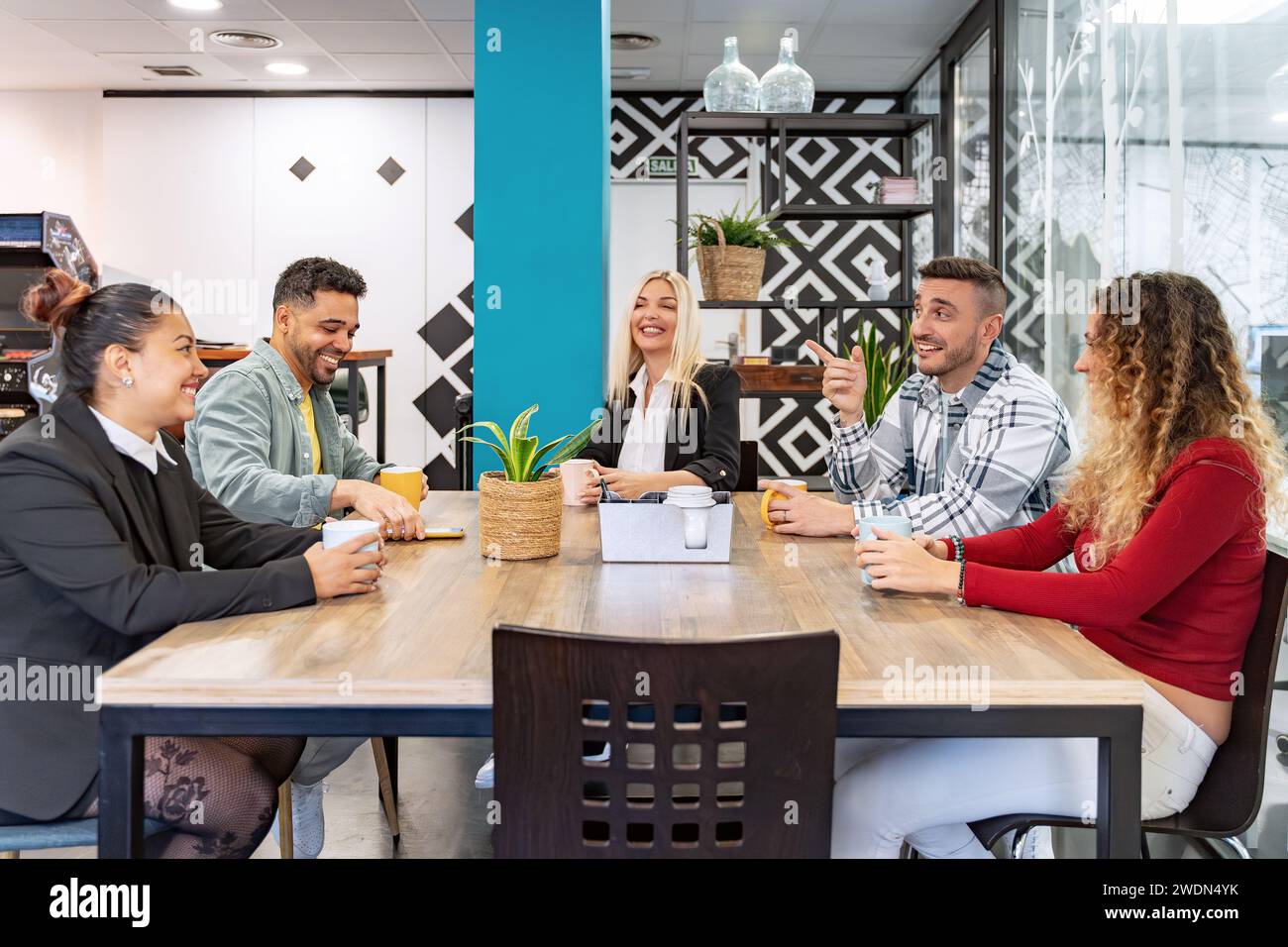 A group of colleagues enjoys a lively and cheerful discussion in a ...