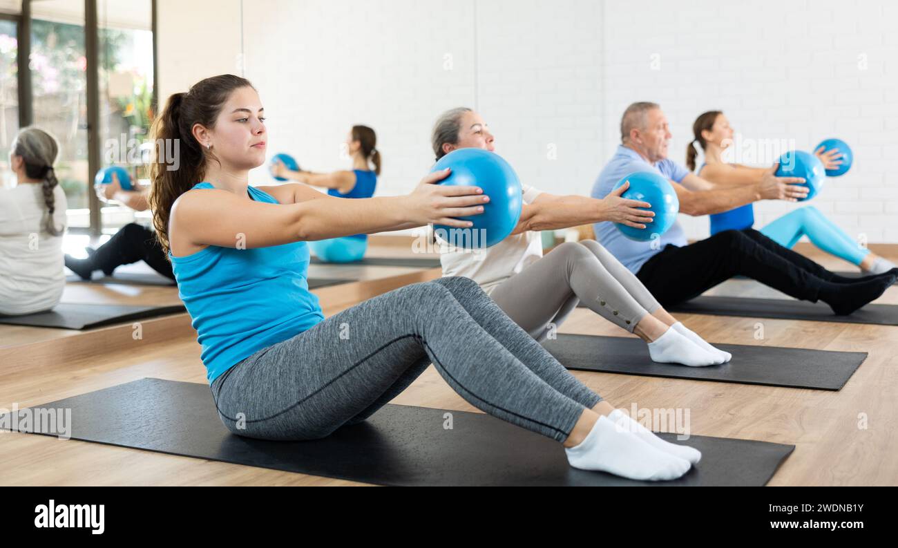 Young girl doing sit-ups with bender ball in pilates studio Stock Photo ...