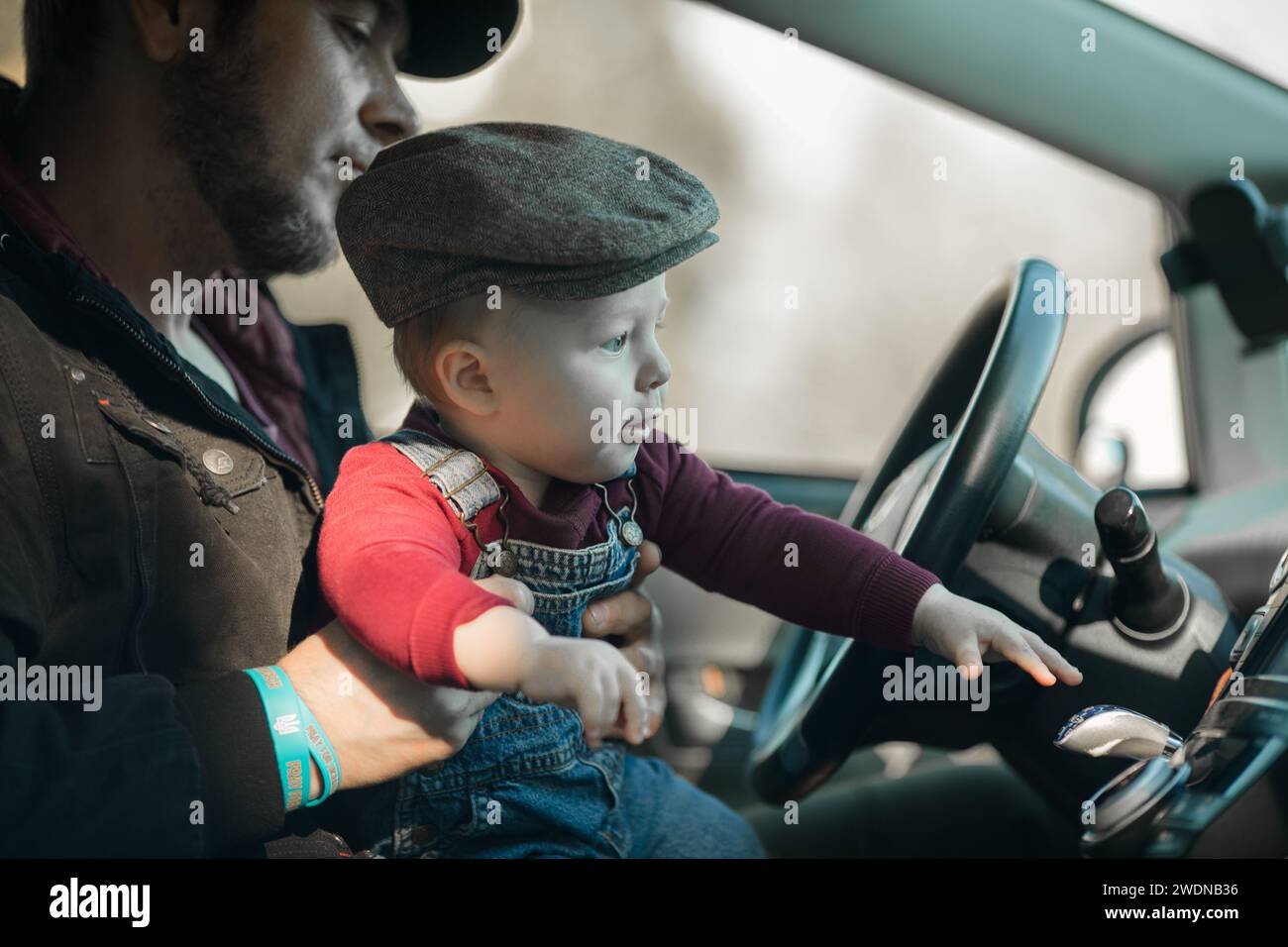 Young father with his little son driving car together. Child sit on dad ...