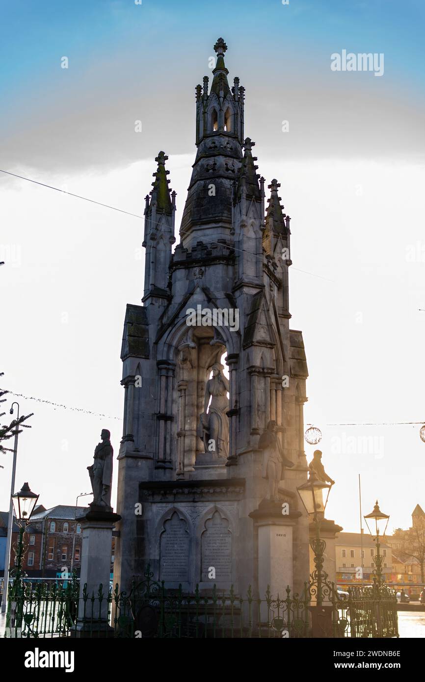 Silhouette of a gothic monument against a sunset sky with urban ...