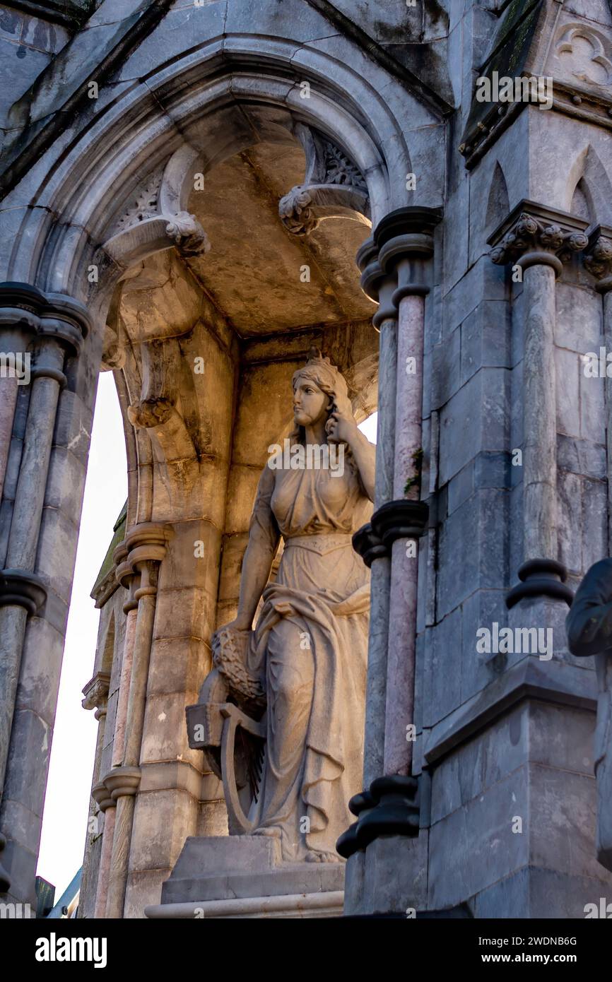 Elegant stone statue of a woman in a niche with gothic architectural ...