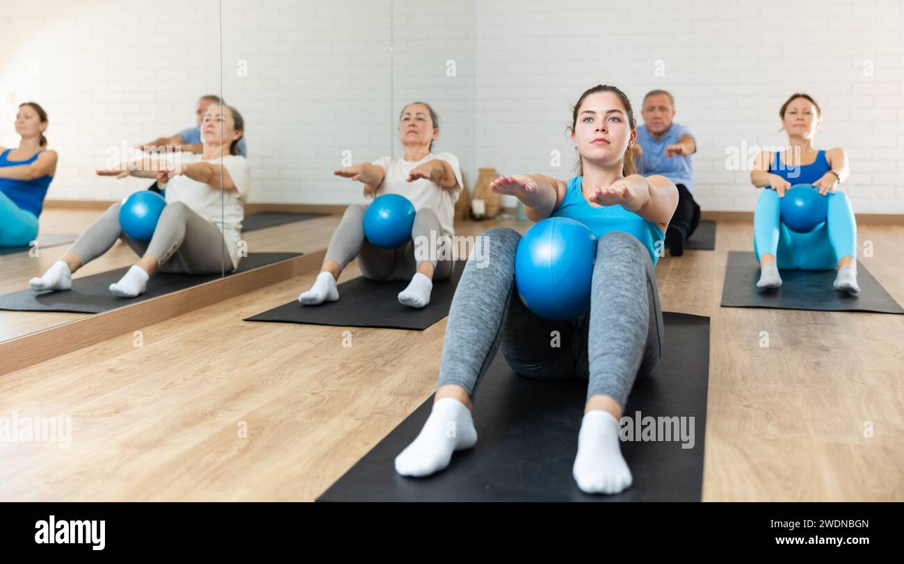 Young girl doing sit-ups with bender ball in pilates studio Stock Photo ...