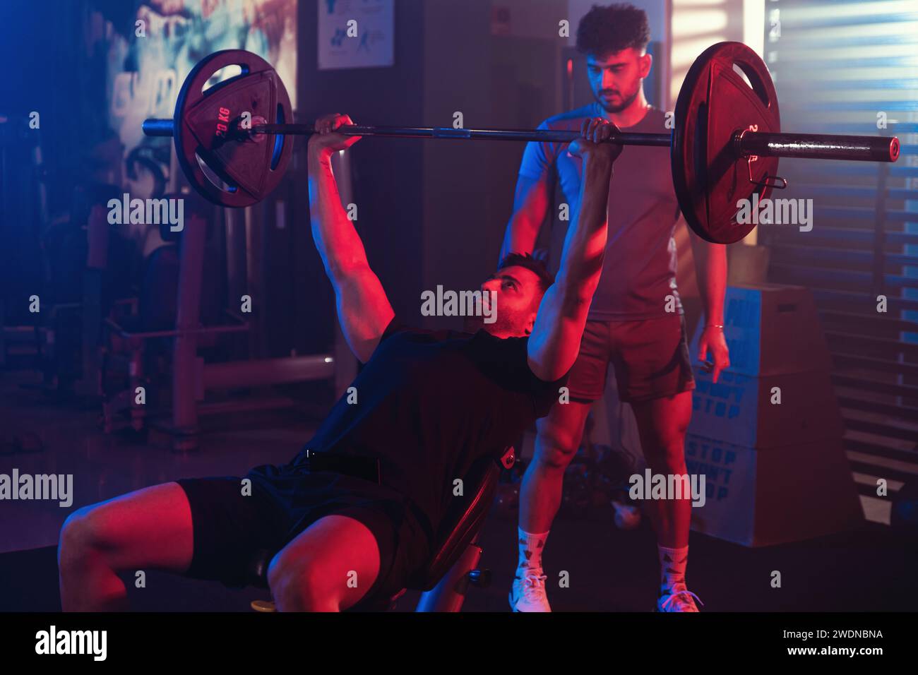 Focused male athlete performing an incline bench press under the ...
