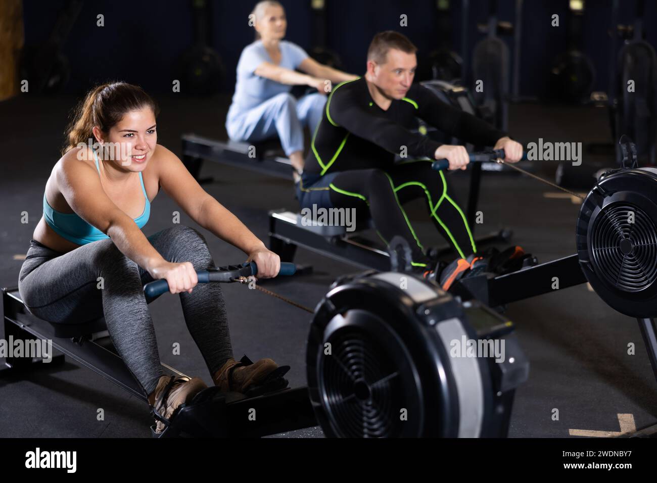 Sporty young woman using cable row machine in gym Stock Photo - Alamy