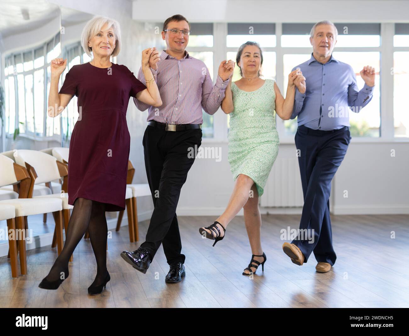 Positive adults forming line while rehearsing traditional Irish ...