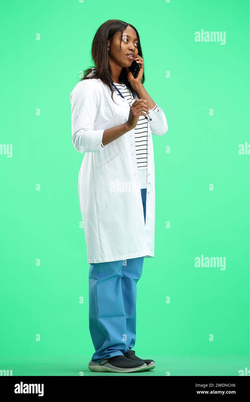Female doctor, full-length, on a green background, with a phone Stock ...