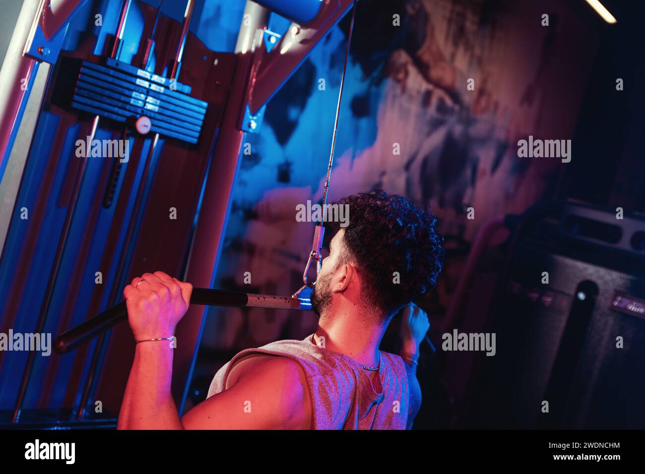 A man perfects his form on the lat pull down machine, a fusion of focus ...