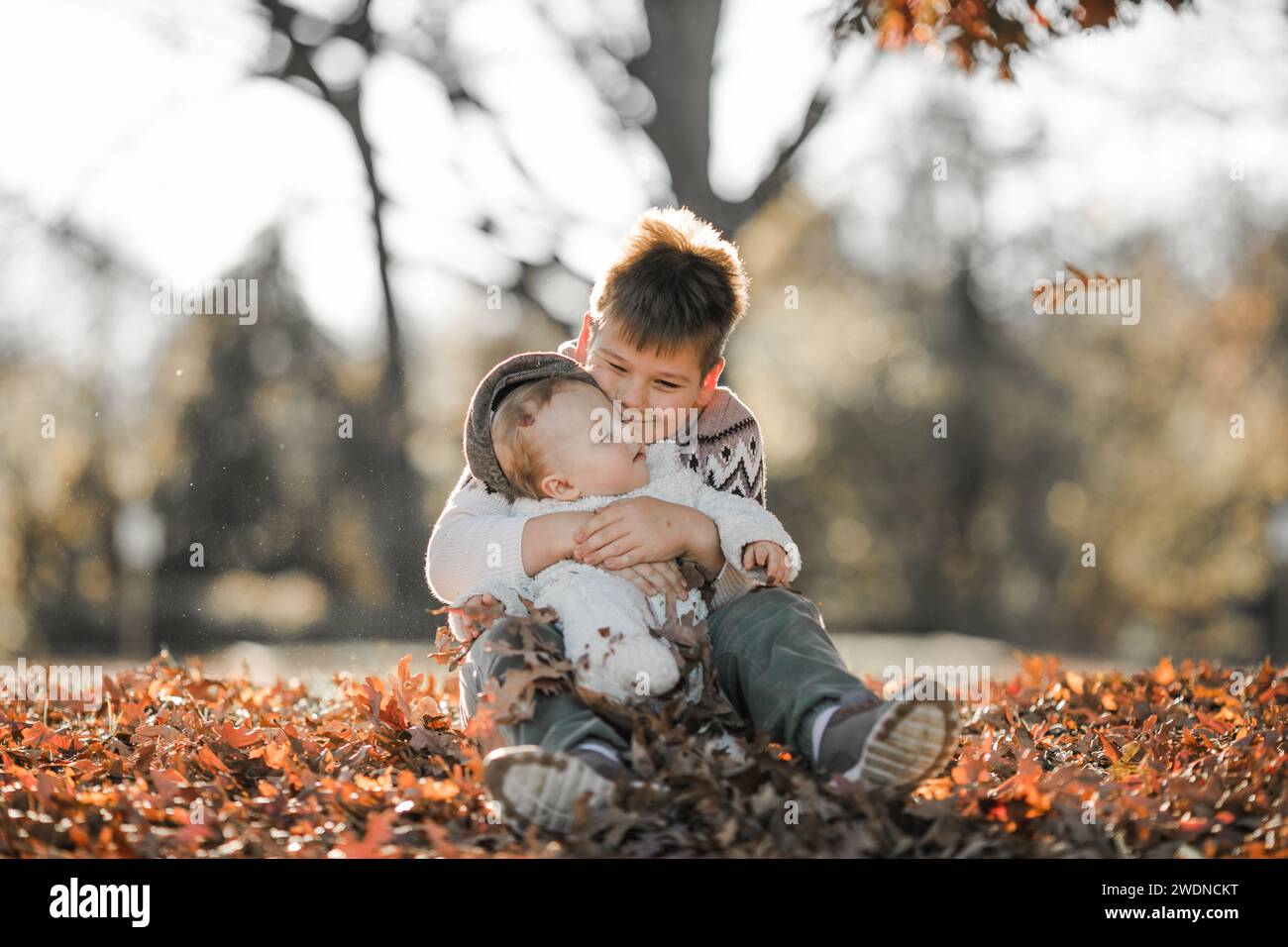 the oldest child hugs and communicates with his 6-month-old brother ...