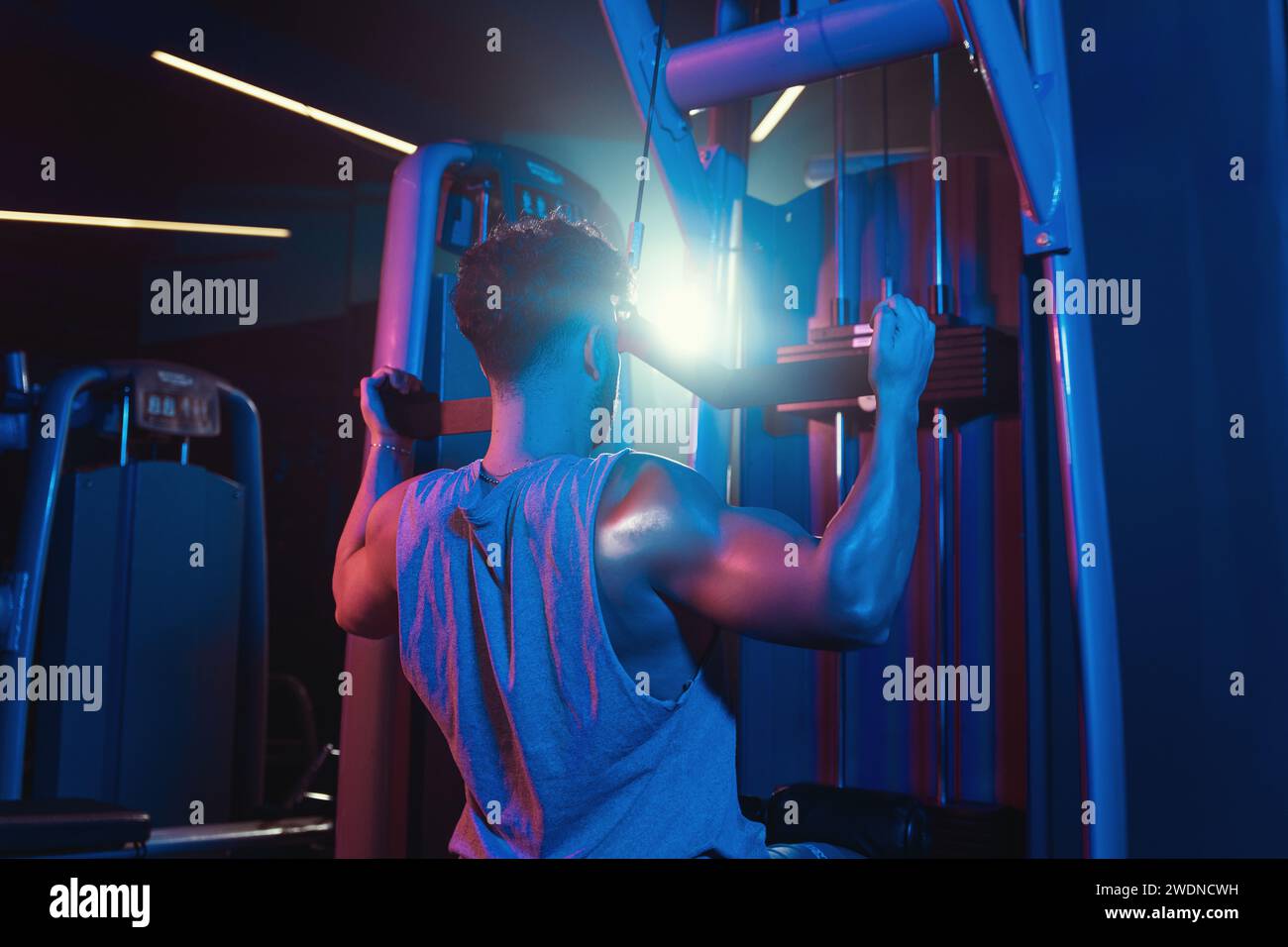 A man perfects his form on the lat pull down machine, a fusion of focus ...