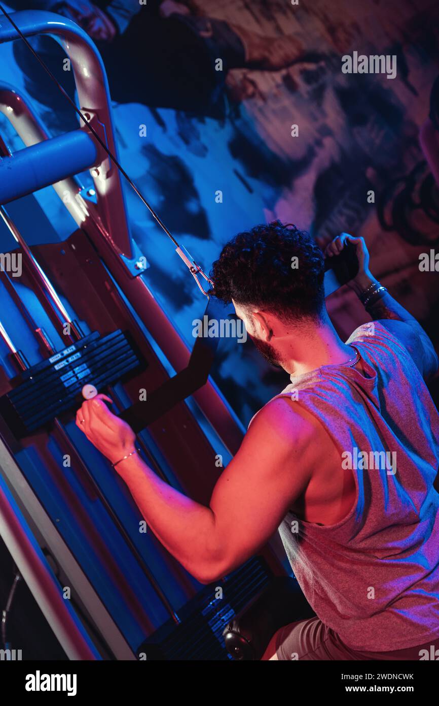 A man perfects his form on the lat pull down machine, a fusion of focus ...