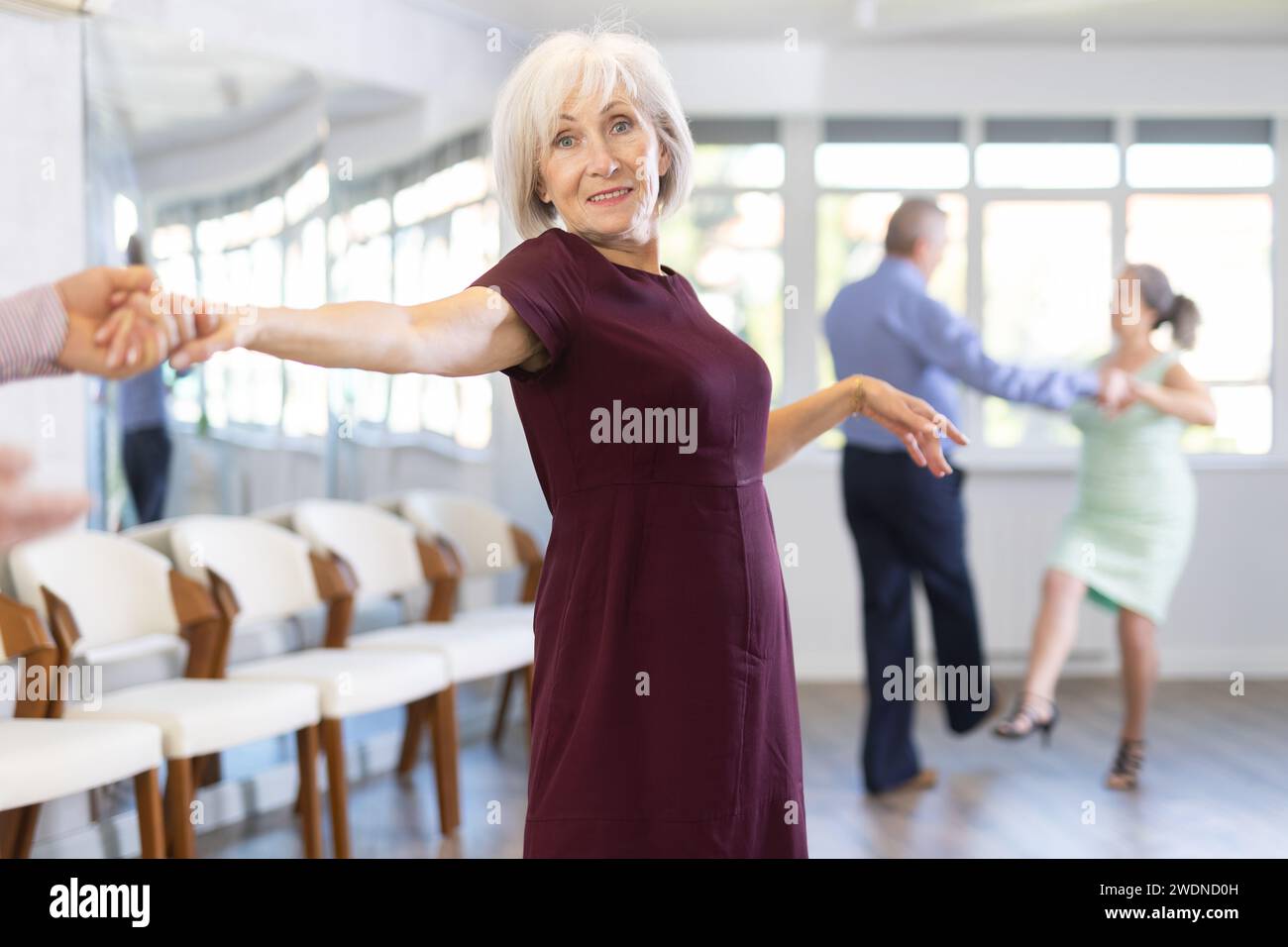 Happy elderly lady with man in elegant clothes dancing bachata in ...