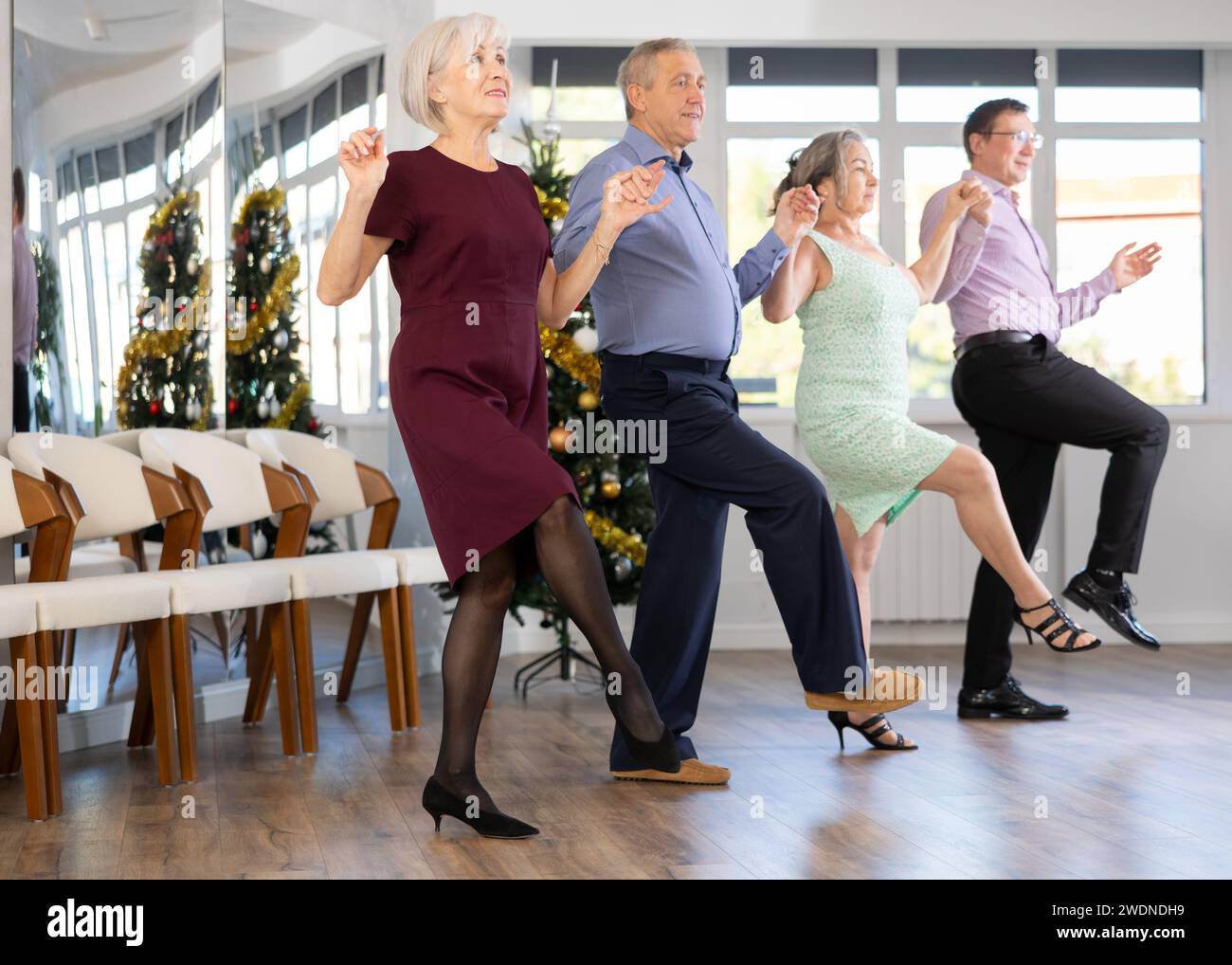 Group of elderly people with middle-aged man perform Irish folk dance ...
