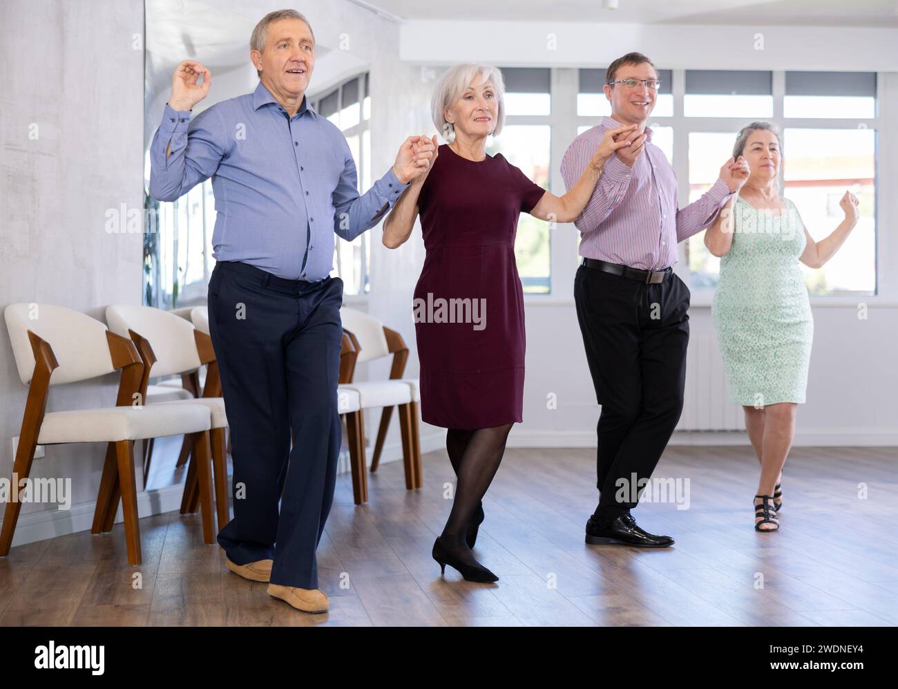 Group of elderly people with middle-aged man perform Irish folk dance ...