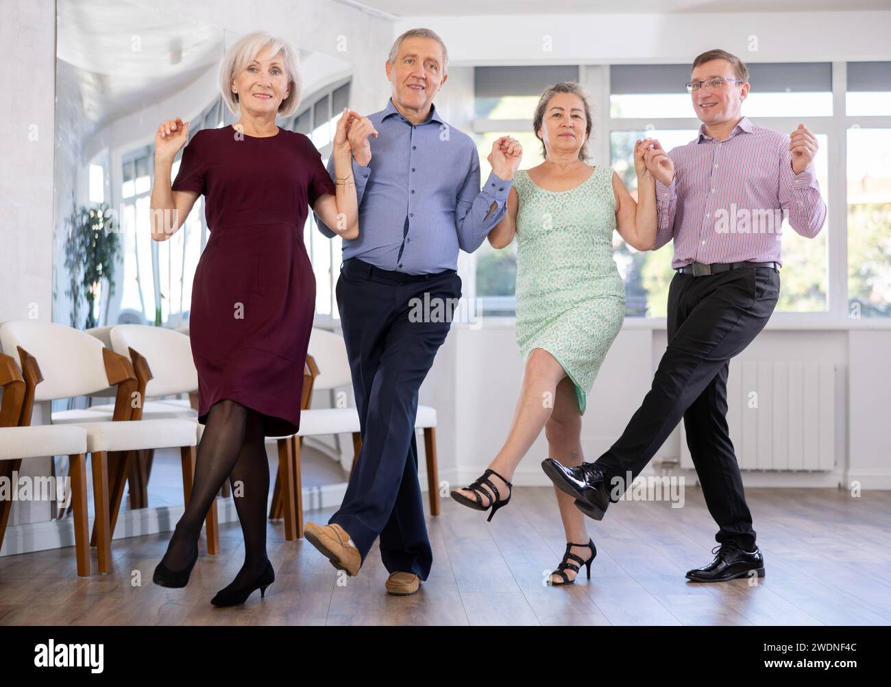 Group of elderly people with middle-aged man perform Irish folk dance ...