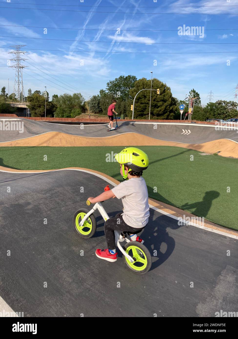 Vibrant pumptrack ride: Child in helmet on a white and fluorescent ...