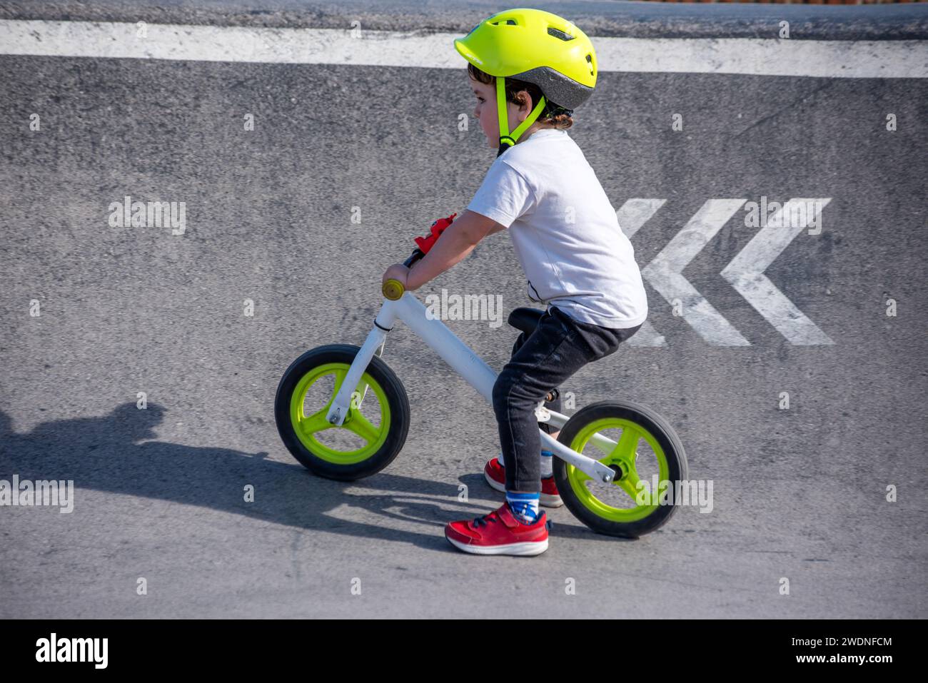 Vibrant pumptrack ride: Child in helmet on a white and fluorescent ...