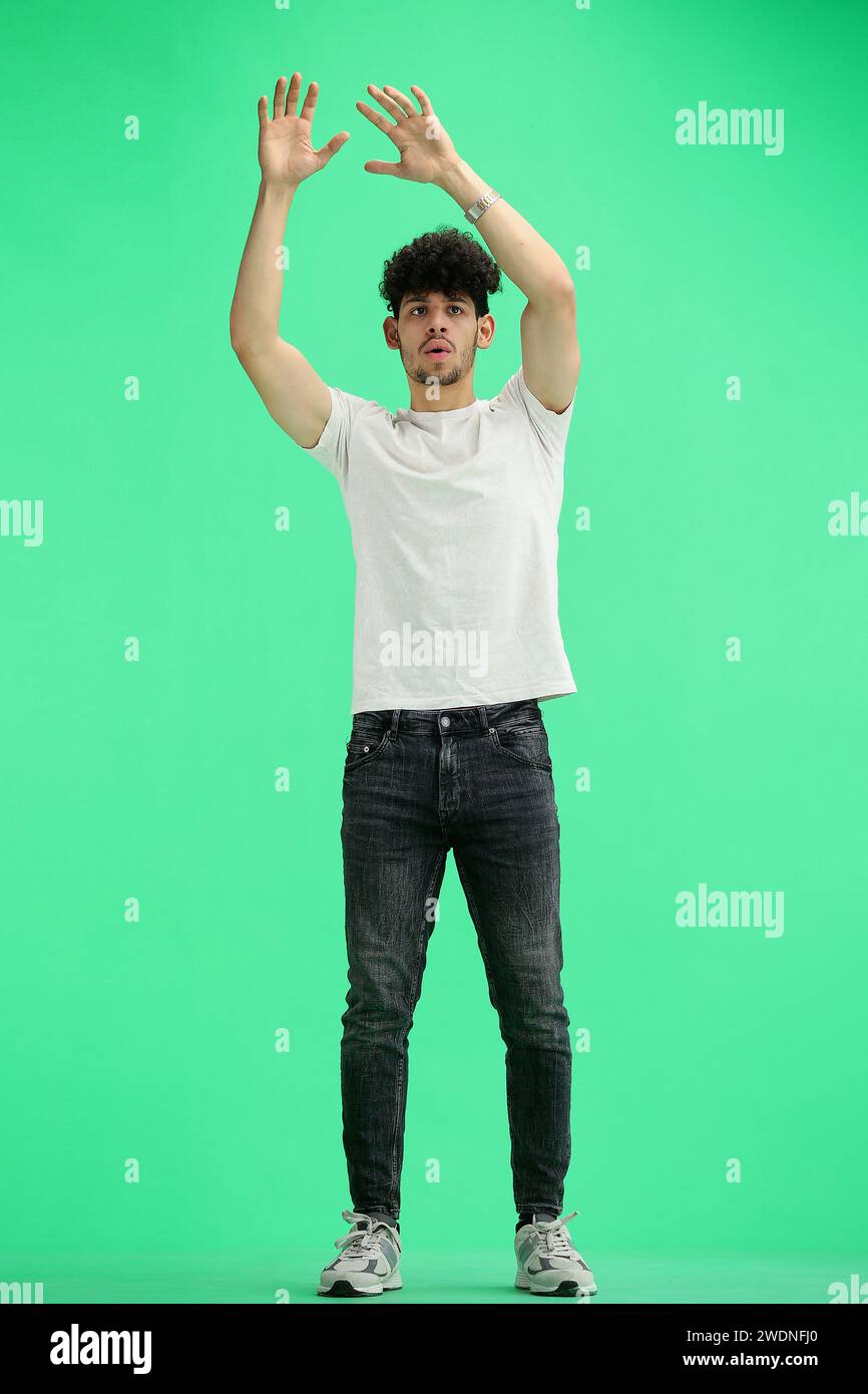 A man, on a green background, in full height, waving his arms Stock ...