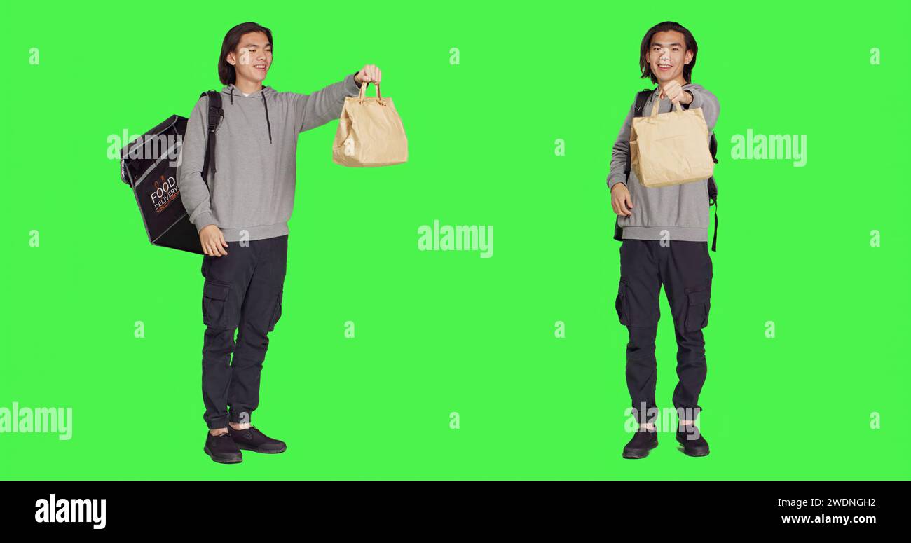 Standing over full body greenscreen, asian guy operates on food ...