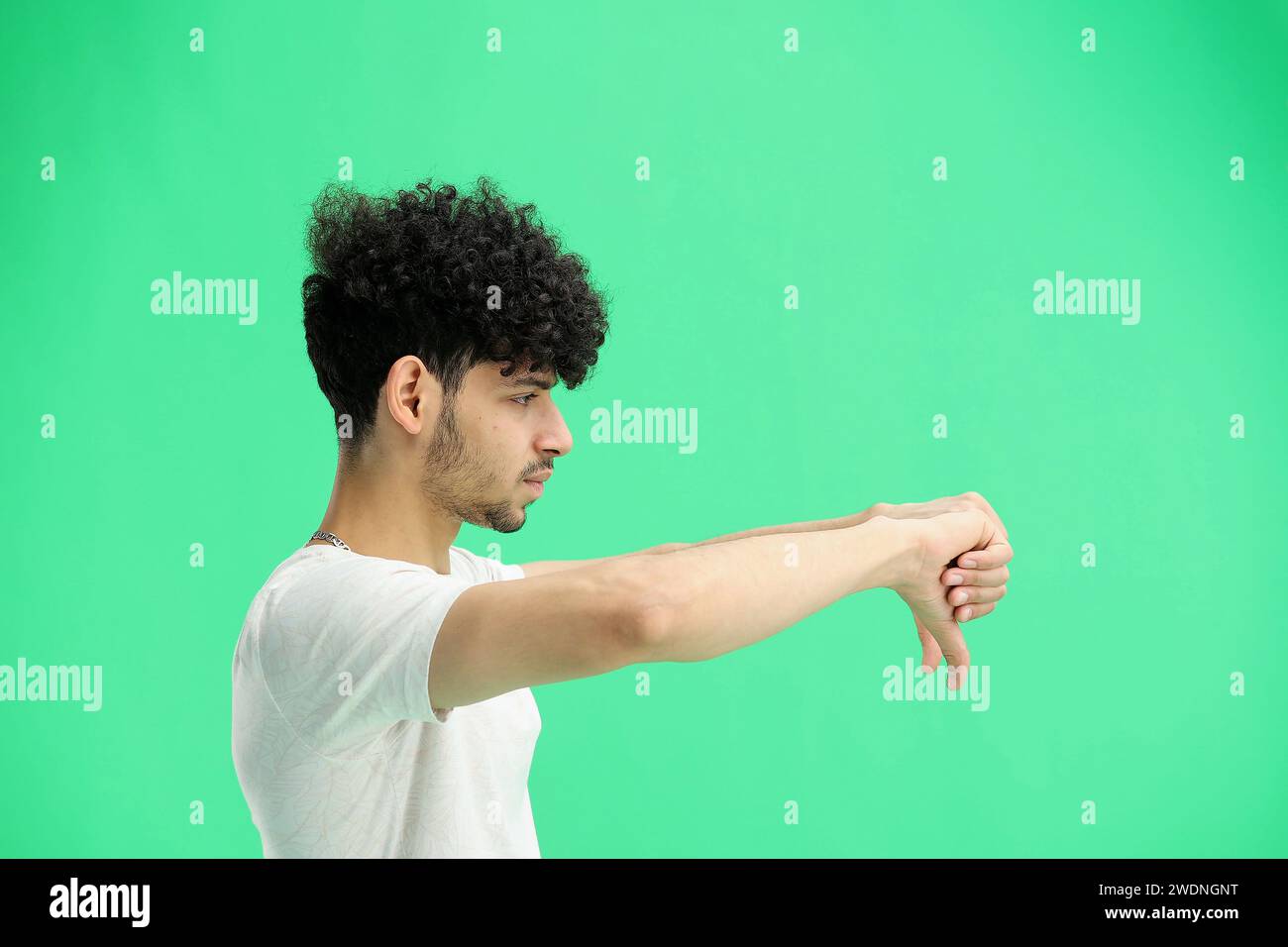 A man, on a green background, in close-up, shows his finger down Stock ...