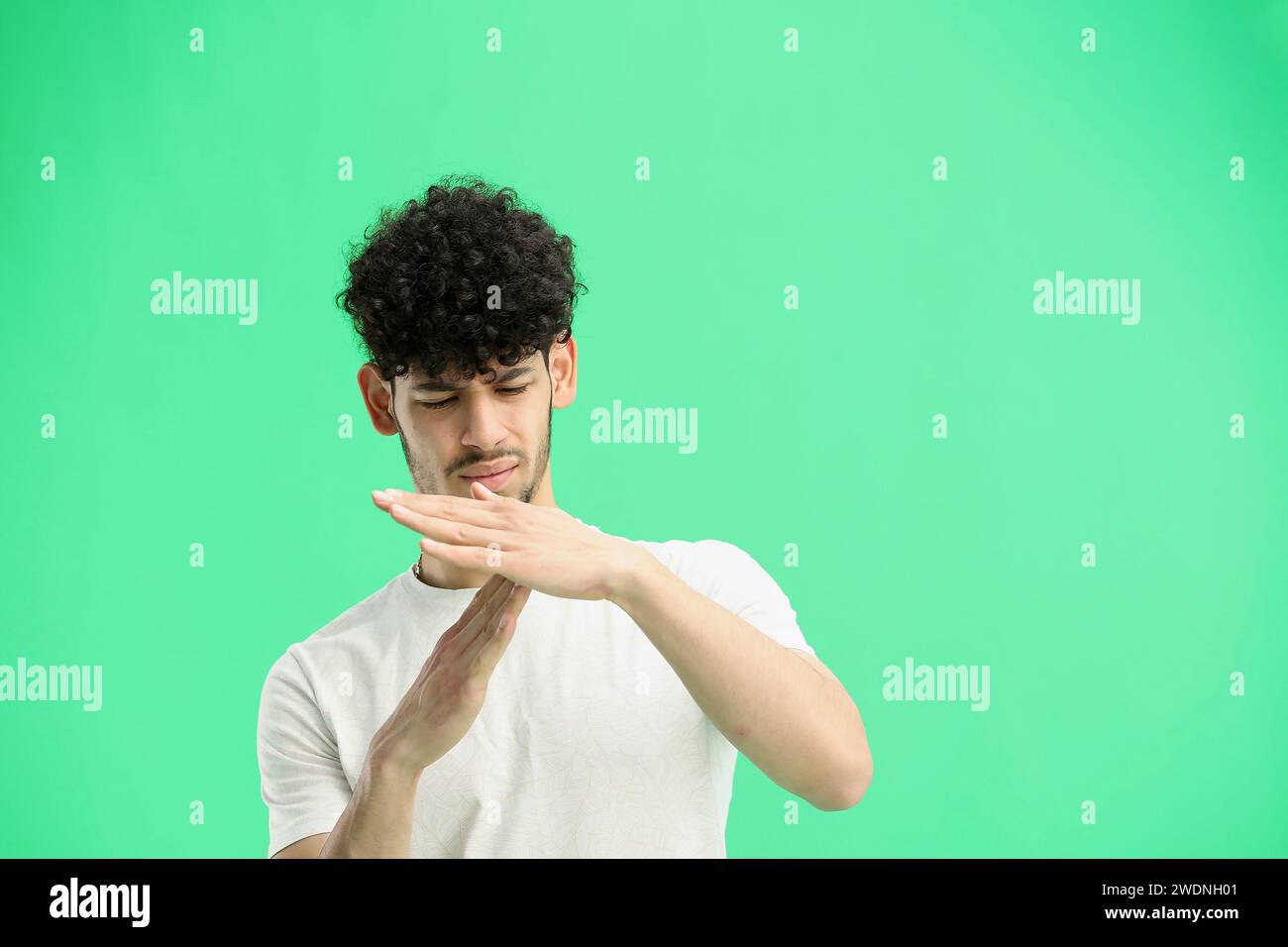 A man, on a green background, in close-up, shows a pause sign Stock ...