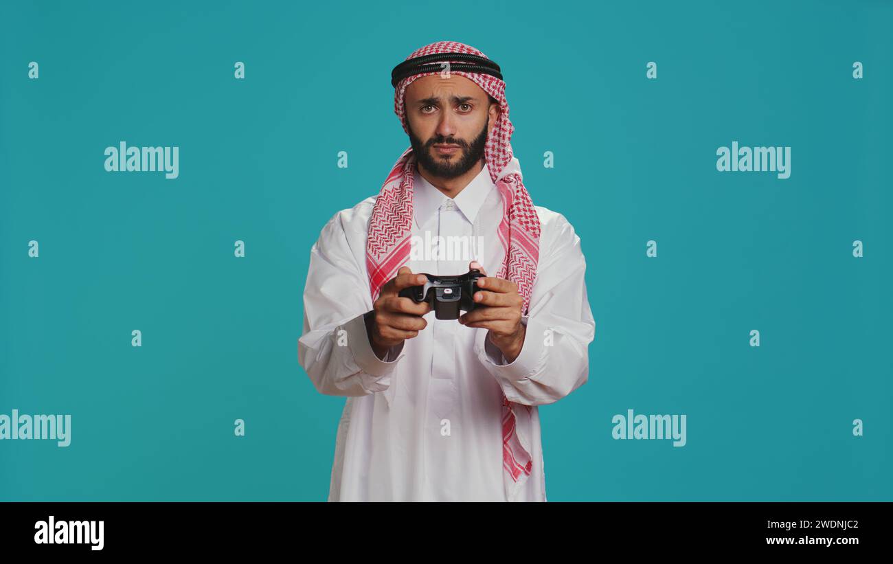 Cheerful adult playing videogames with joystick, having fun with online ...